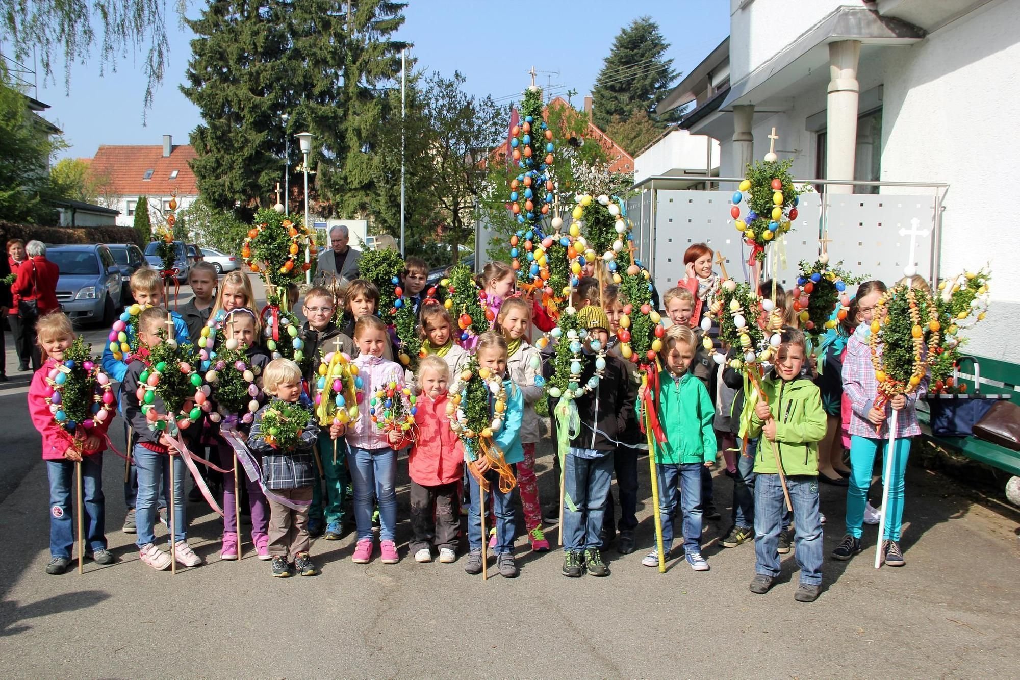Kinder ziehen mit schönen Palmen in die Kirche Maria Königin